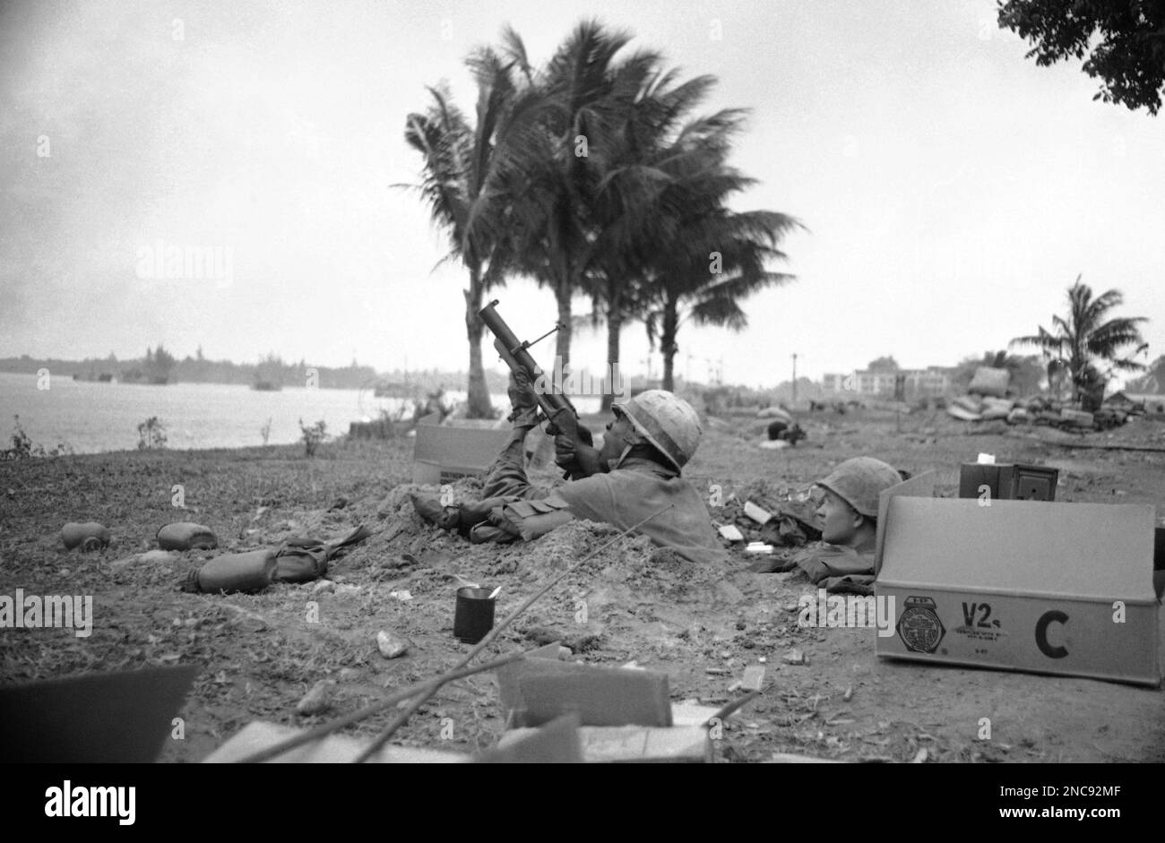 U.S. Marine at left fires an M79 grenade launcher from his fighting ...