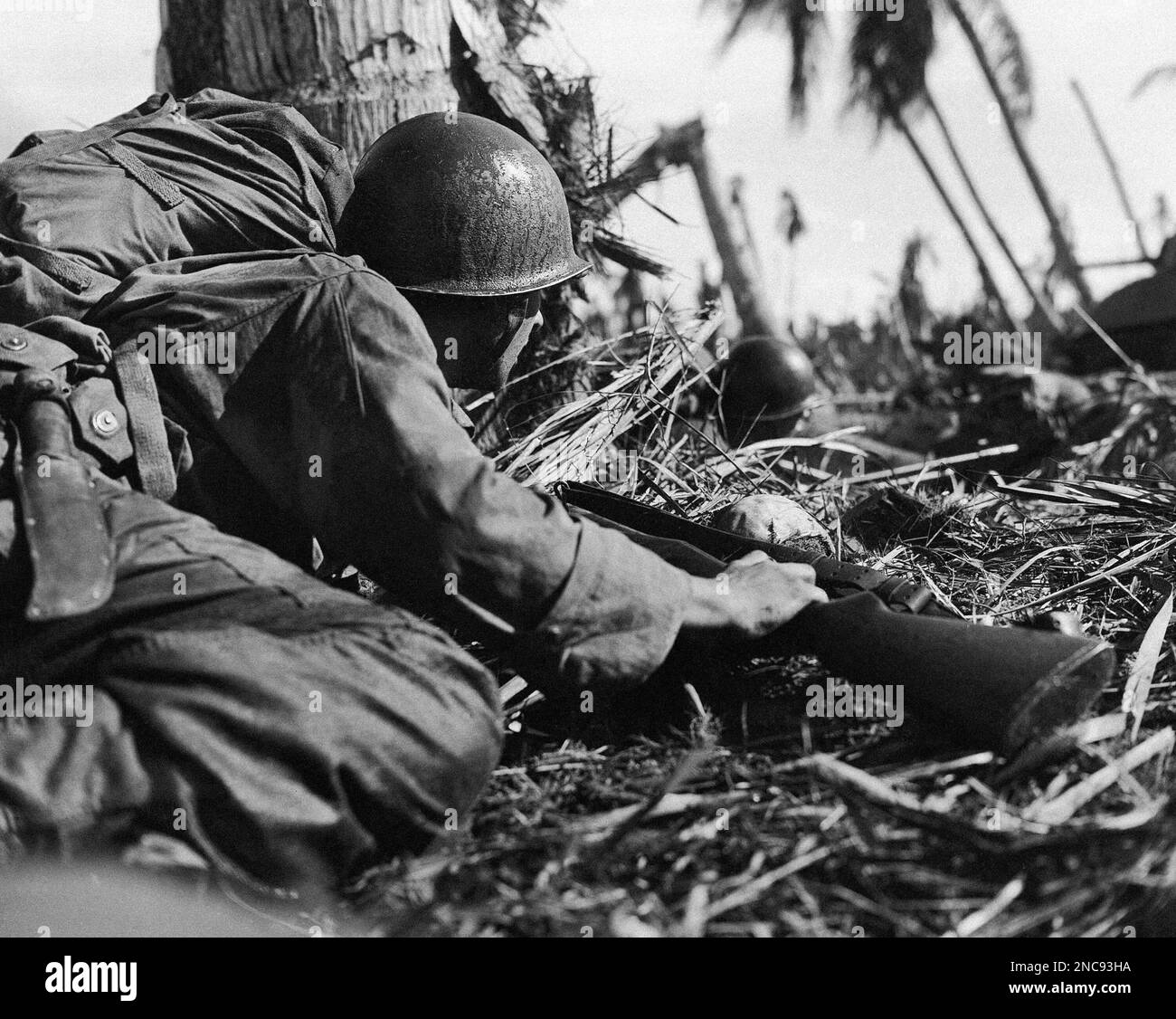 Rifle held before him, an American soldier prepares to plunge forward ...