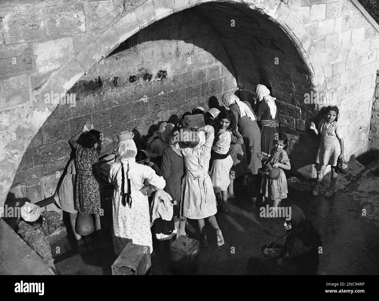 Arab women and children draw water from Mary’s well in Nazareth, Israel ...