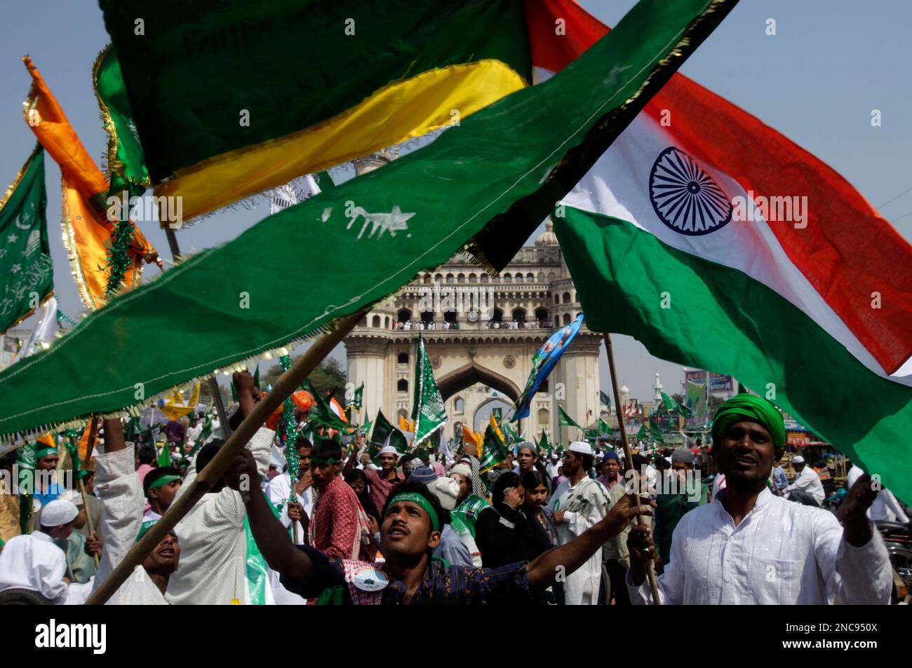 Indian Muslims wave the Indian national flag along with religious flags ...