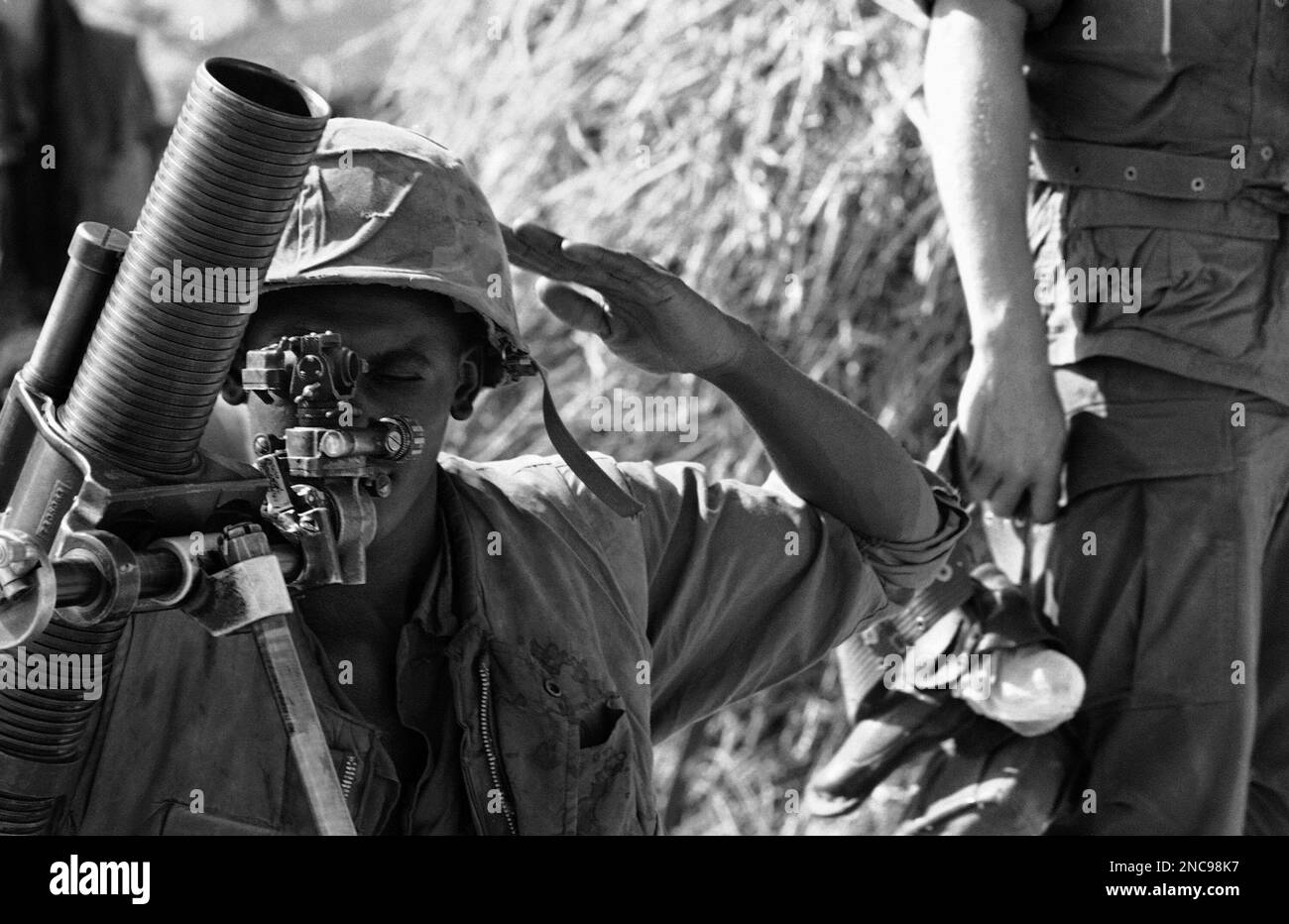 A U.S. Marine Mortarman signals his 81mm mortar is on target as he aims ...