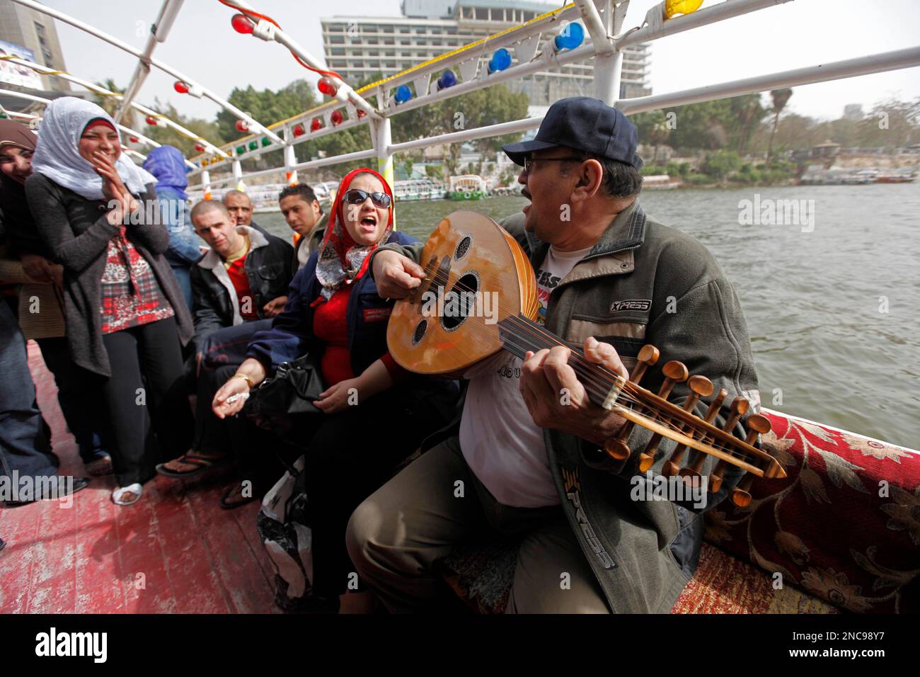 Egyptian sing as they enjoy a ride along the Nile during the Islamic ...