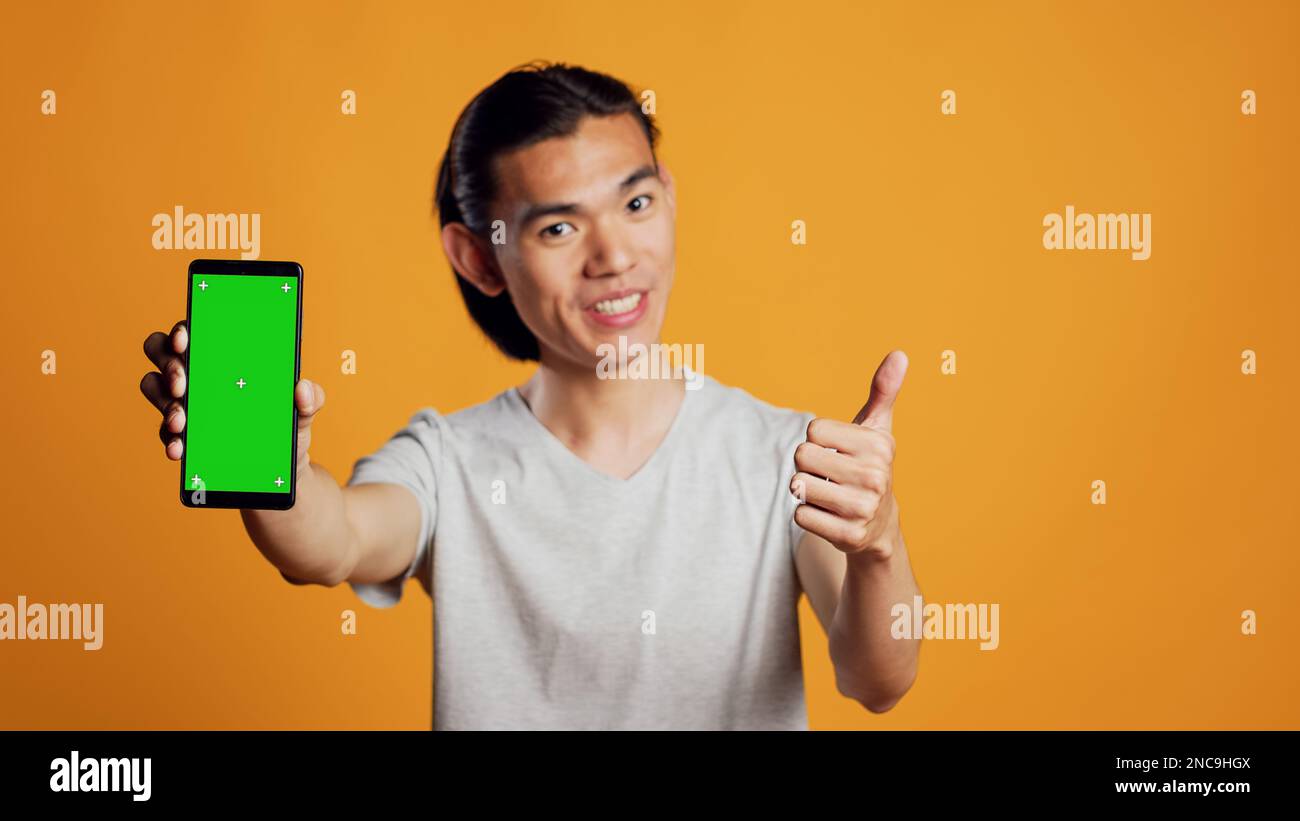Happy person using greenscreen template on smartphone, showing isolated ...