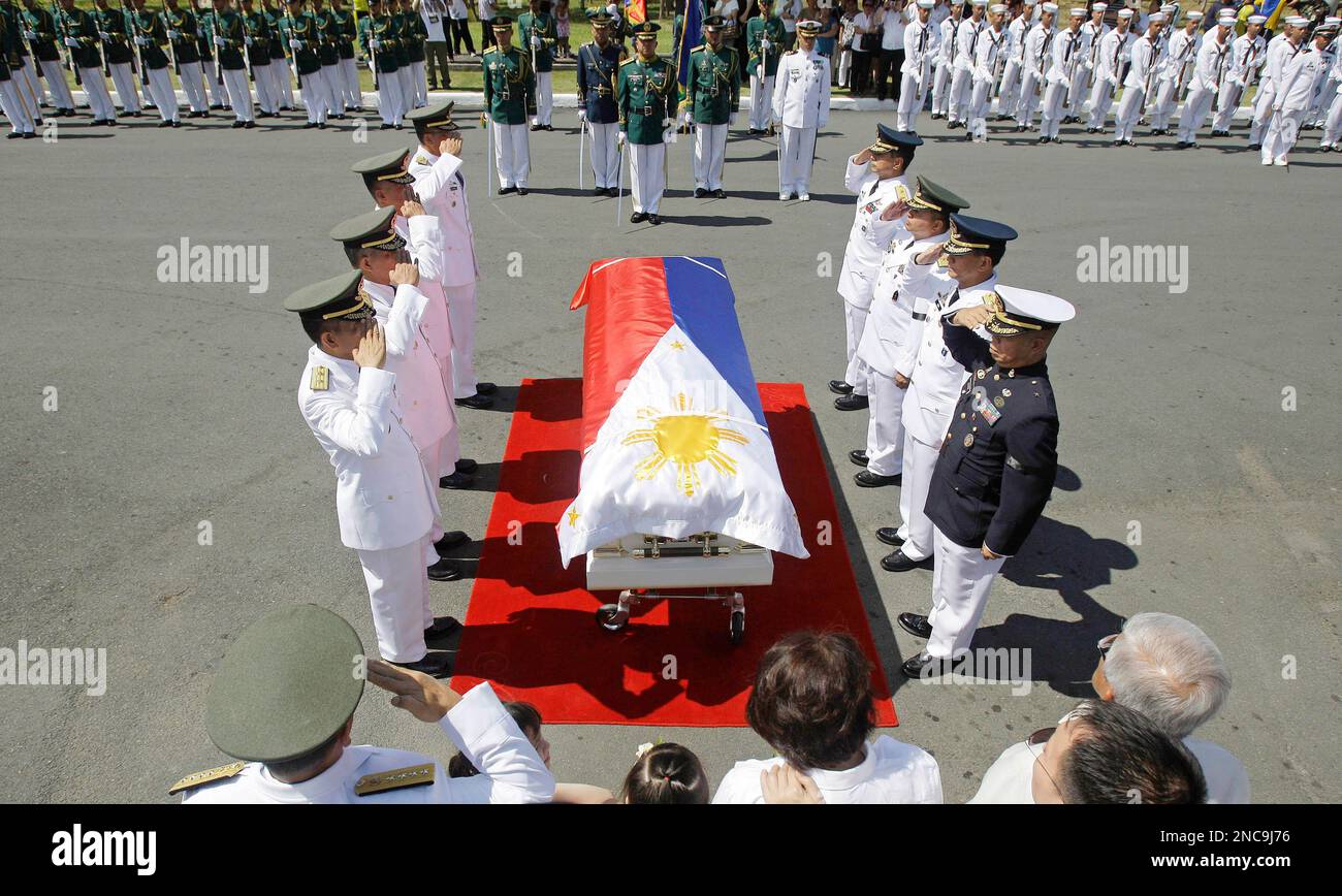 Military officers salute during the burial of ret. Gen. Angelo Reyes at ...