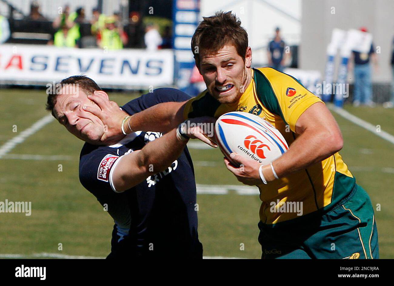 Australia's Bernard Foley, right, runs past Scotland's Scott Riddell ...