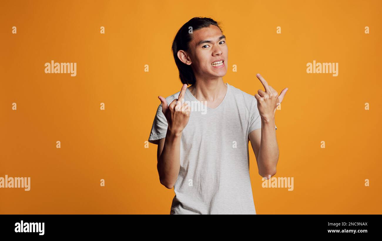 Violent male model showing middle fingers in studio, expressing furious ...