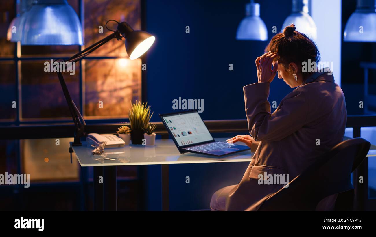 Executive manager analyzing economy graphs on screen, working at night ...