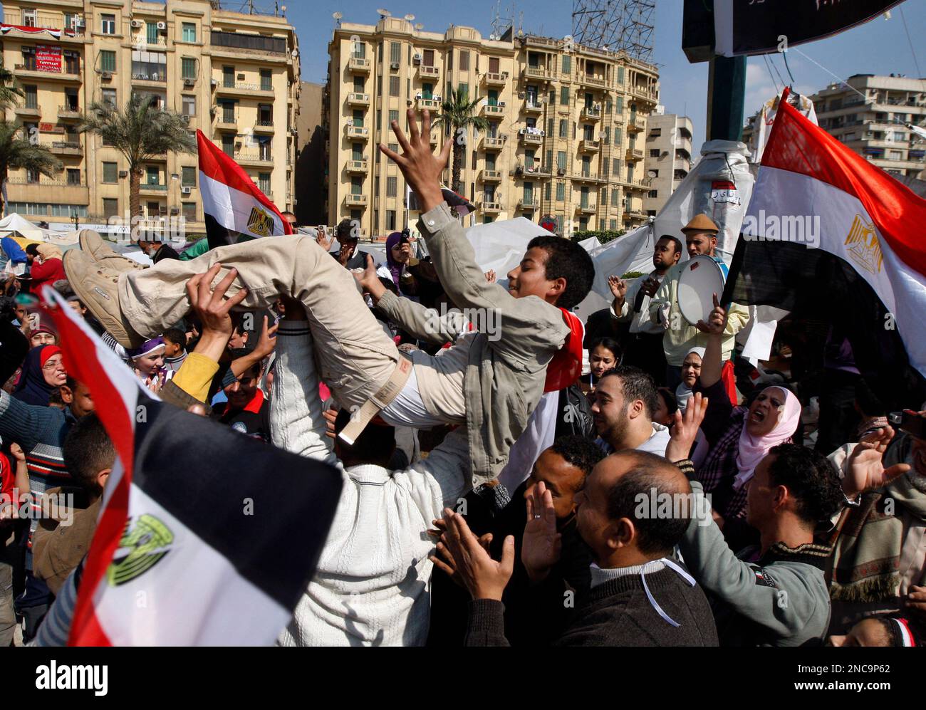 Egyptians dance and wave national flags in Tahrir Square in Cairo ...