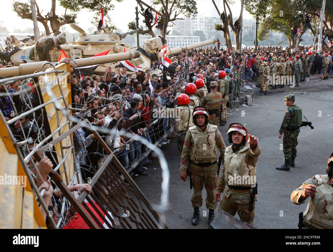 Egyptian soldiers gesture in front of anti-government protesters as ...