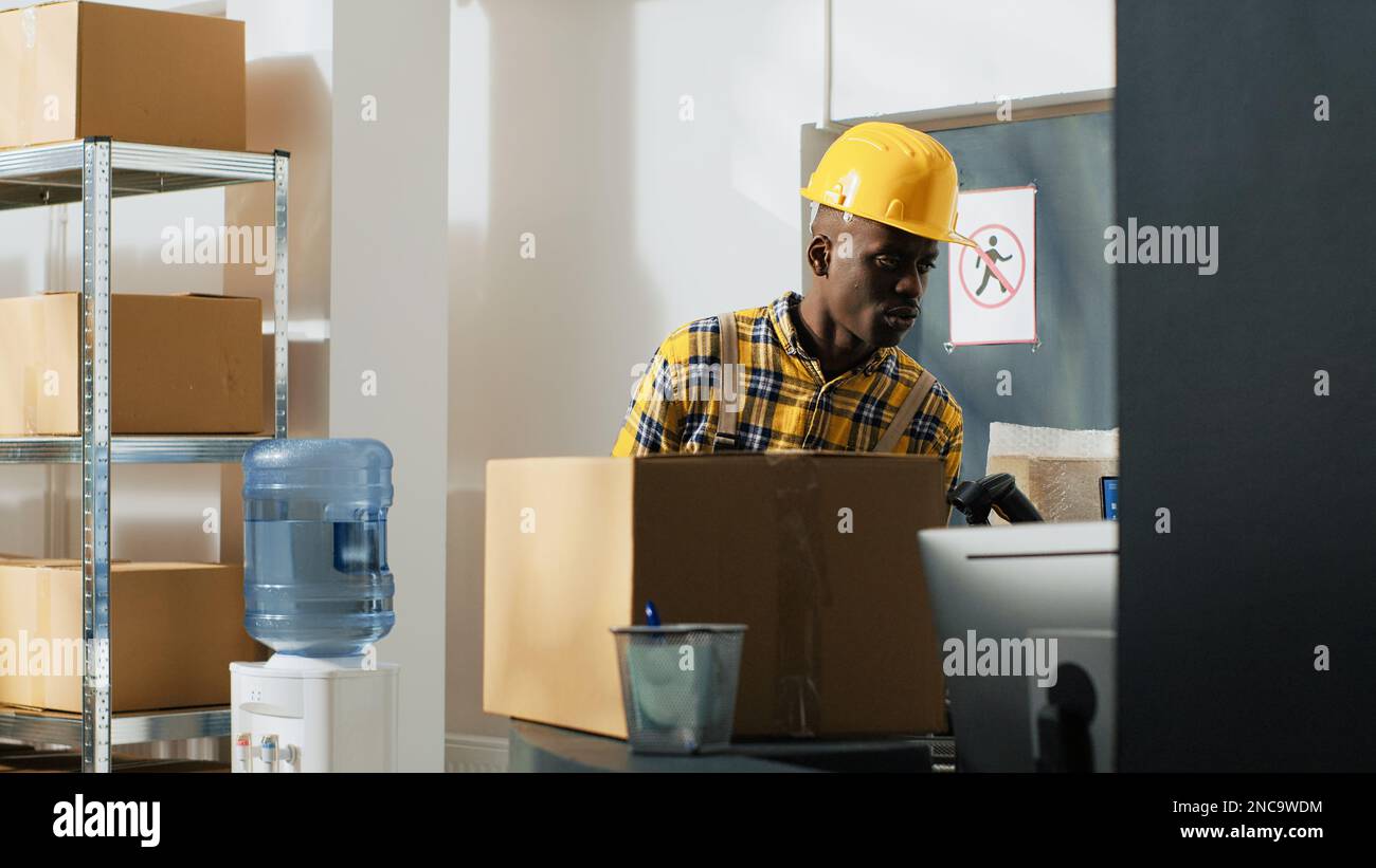 Storage room employees checking boxes of goods in warehouse, using ...