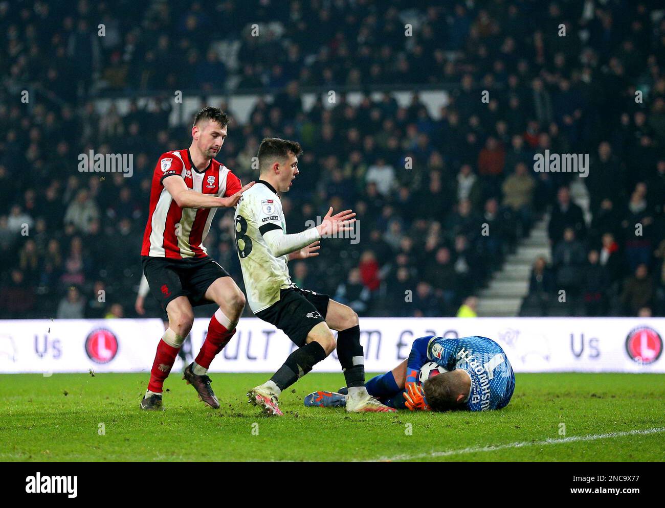 Lincoln City goalkeeper Carl Rushworth saves at the feet of Derby ...