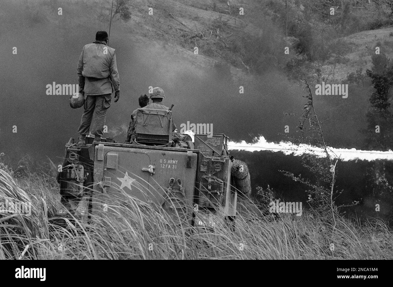 U.S. troops of the 5th Mechanized Division spew napalm from a flame ...