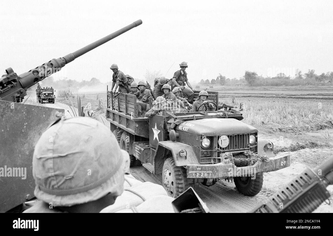 Truckload of U.S. troops in armored convoy moves along road near Trung ...