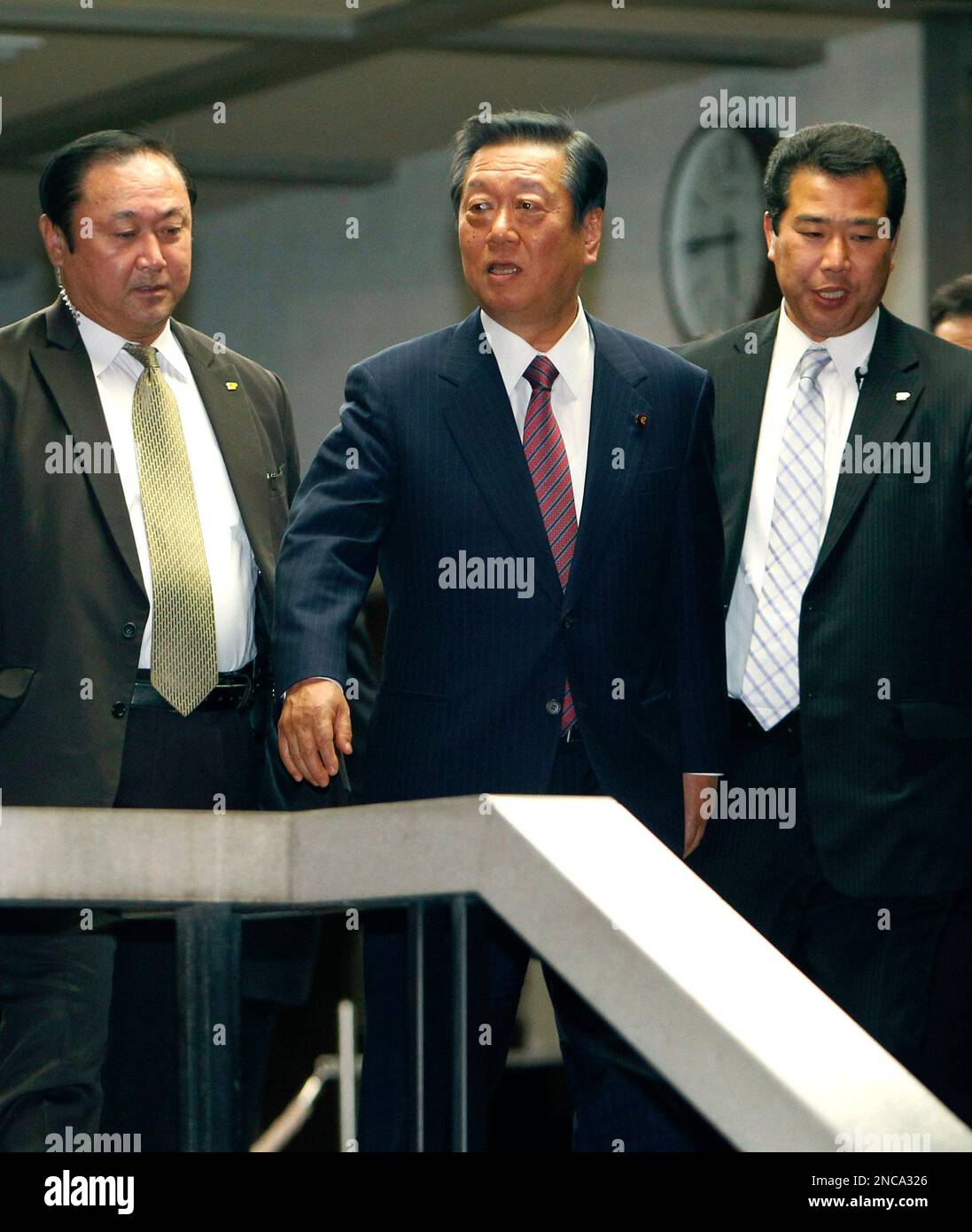 Ichiro Ozawa, center, power broker of the ruling Democratic Party of Japan (DPJ), is escorted by ...