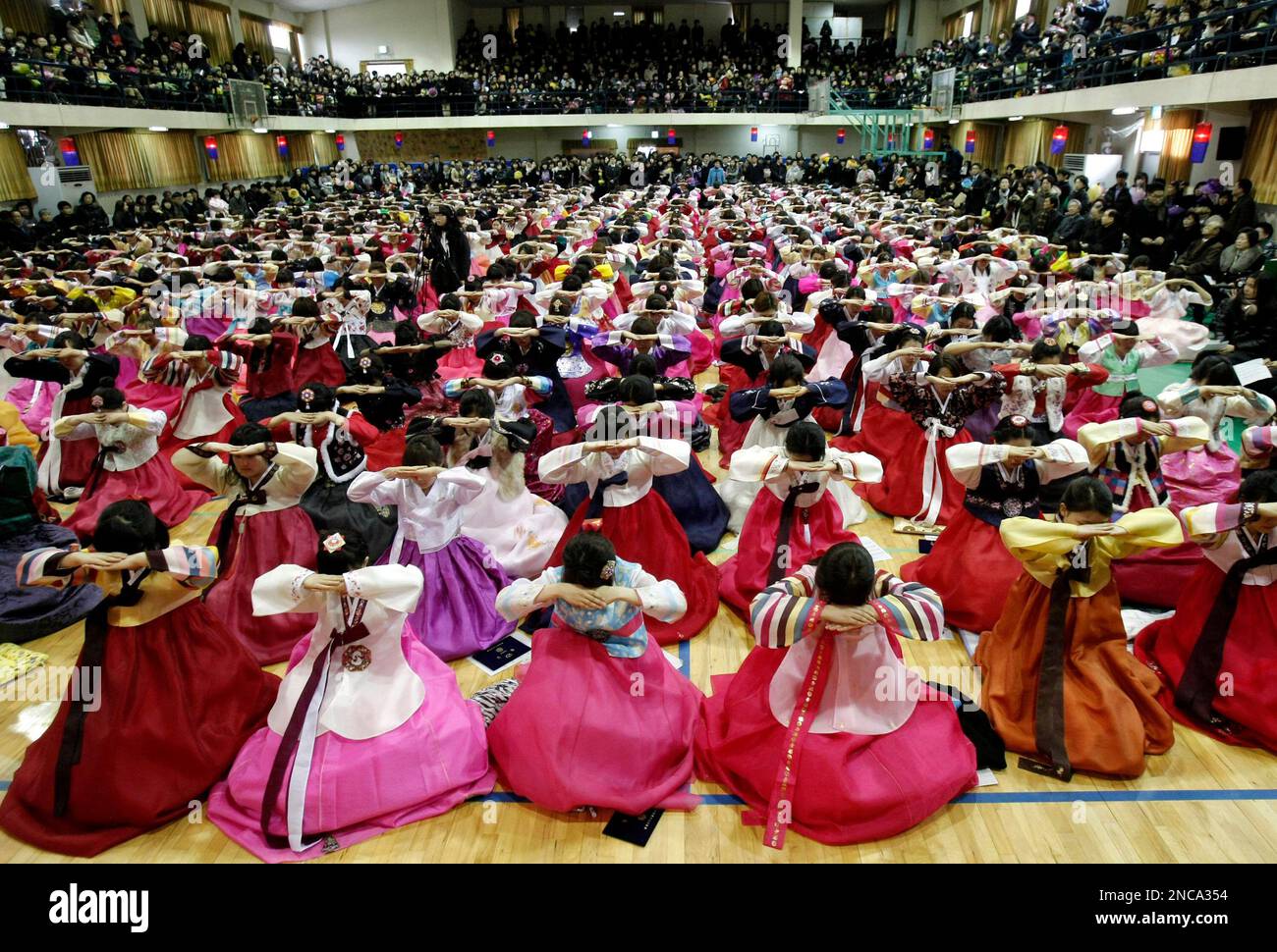 South Korean seniors clad in traditional attire bow during a joint ...