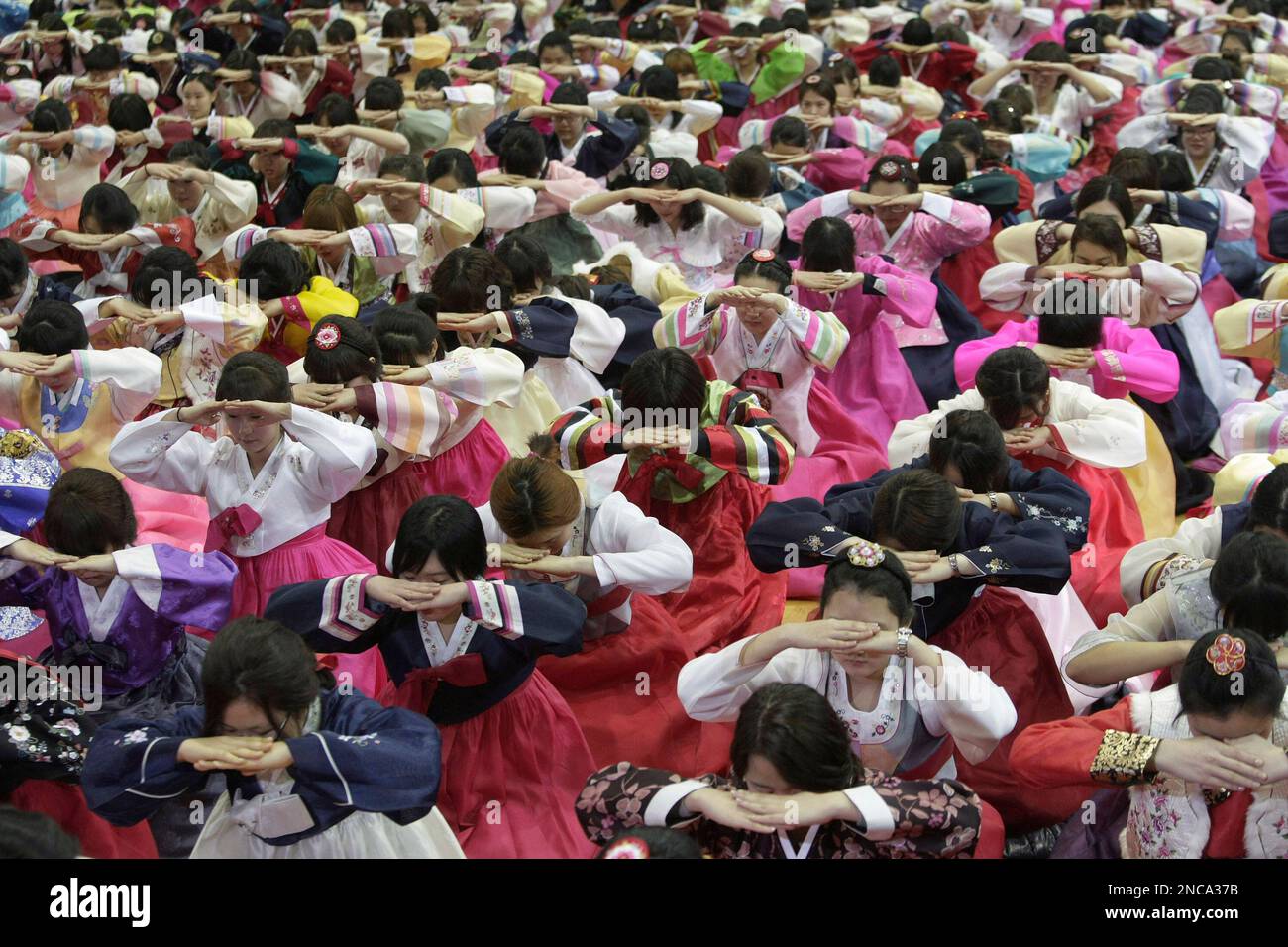 South Korean seniors clad in traditional attire bow during a joint ...