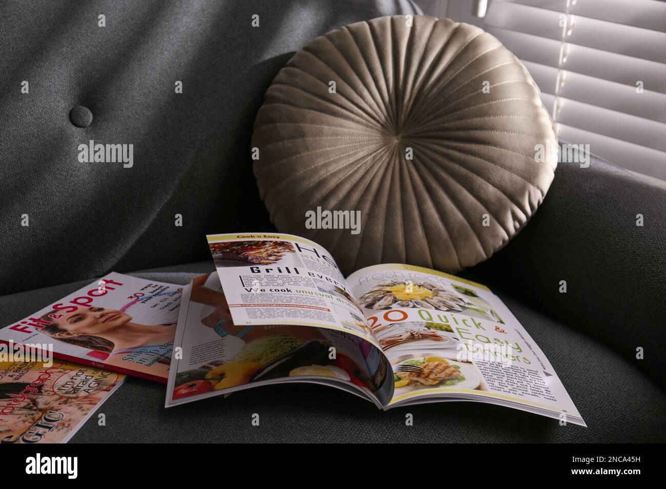 Different lifestyle magazines on comfortable sofa indoors Stock Photo ...
