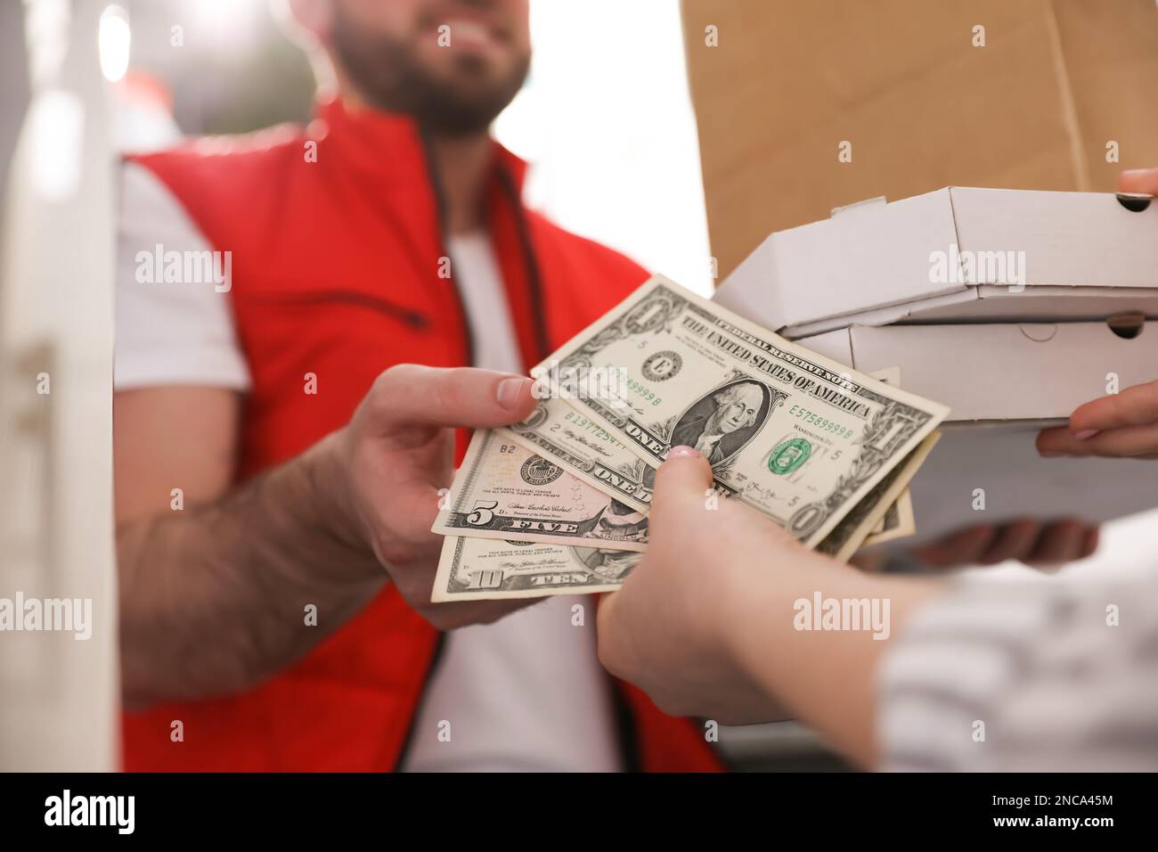 Deliveryman receiving tips from woman indoors. closeup Stock Photo - Alamy
