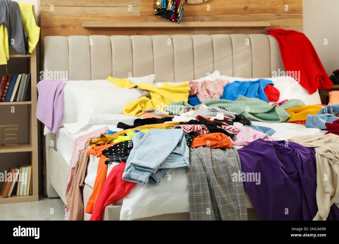 Pile of clothes on bed in messy room. Fast fashion concept Stock Photo ...