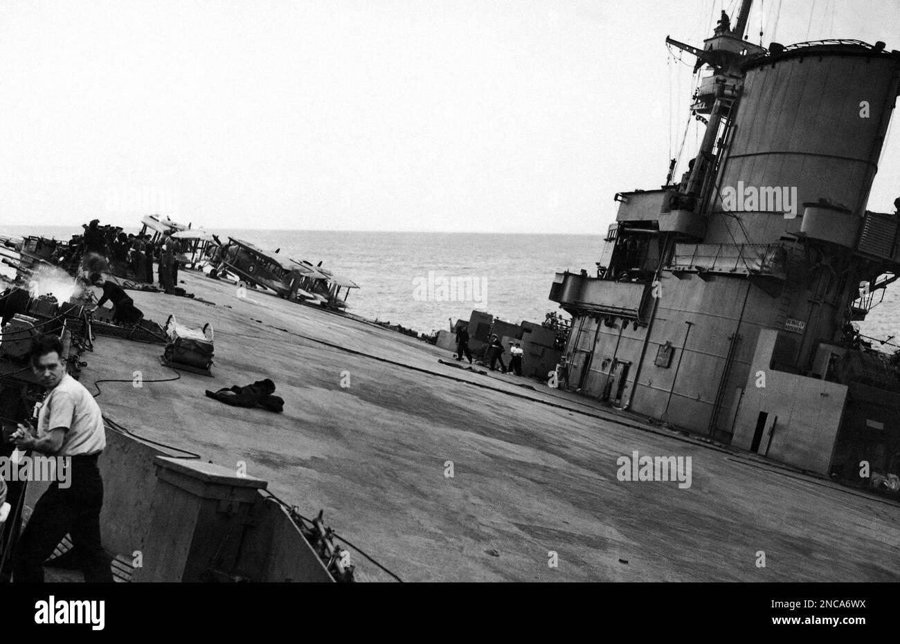 Last scenes on board the sinking British aircraft carrier H.M.S. Ark Royal, showing the flight ...