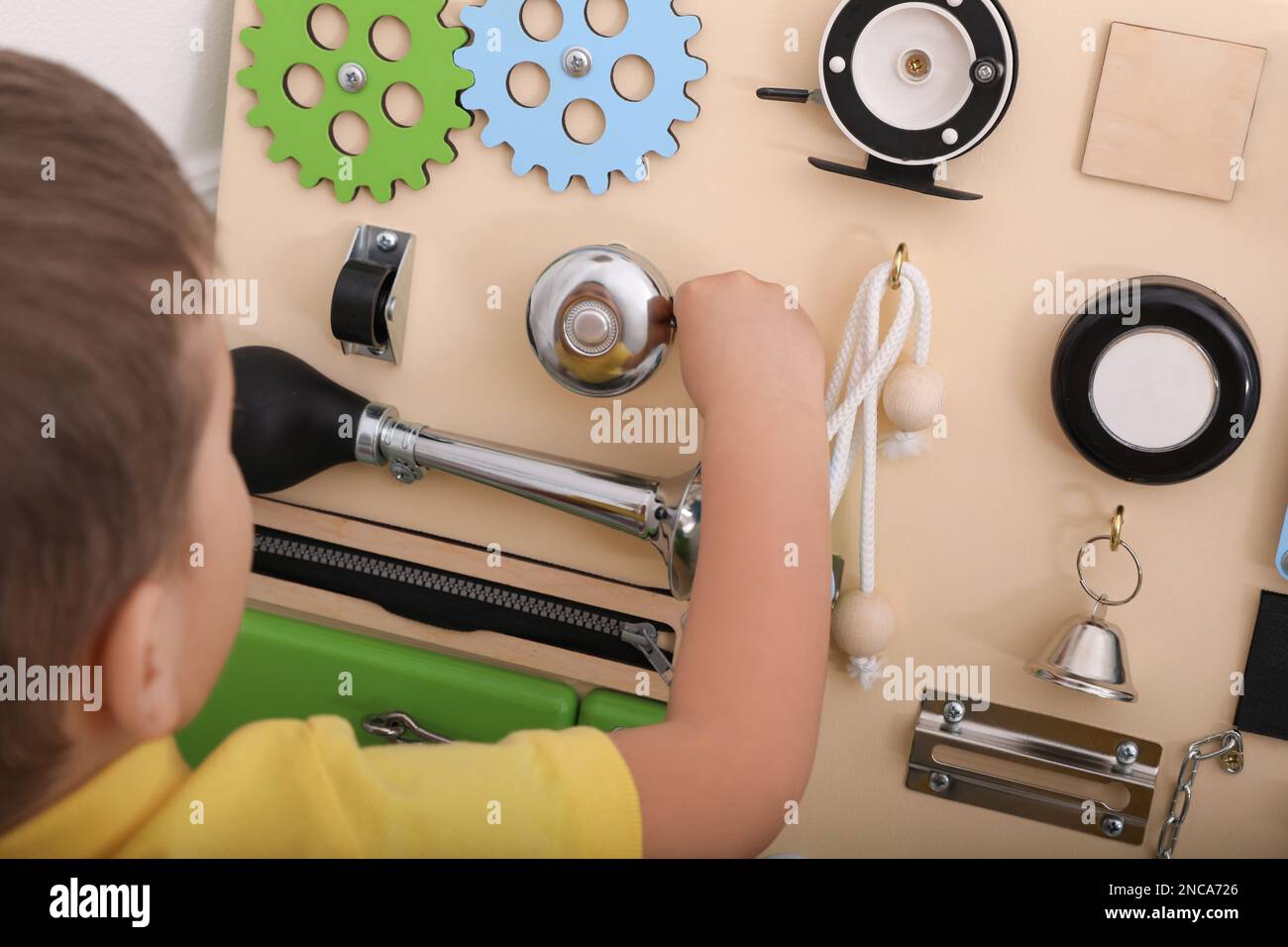 Little boy playing with busy board, focus on hand Stock Photo - Alamy
