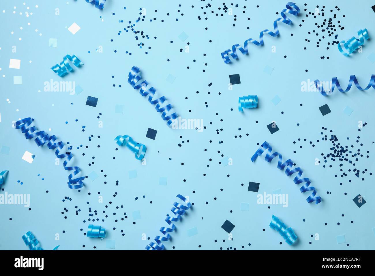 Shiny serpentine streamers and confetti on light blue background, flat ...