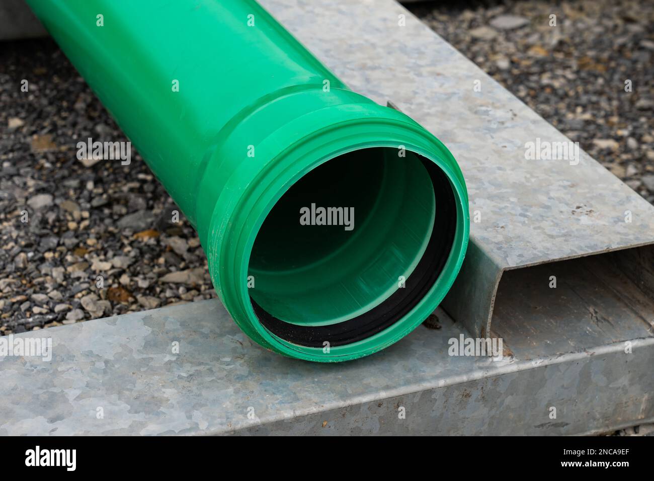 Part of green plastic pipe with a connecting flange at the end. Close ...