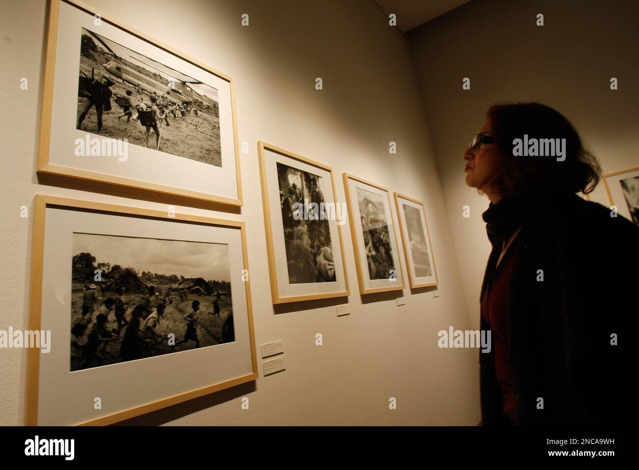 A woman looks at the photos of the the 'Henri Huet, Vietnam' exhibition ...