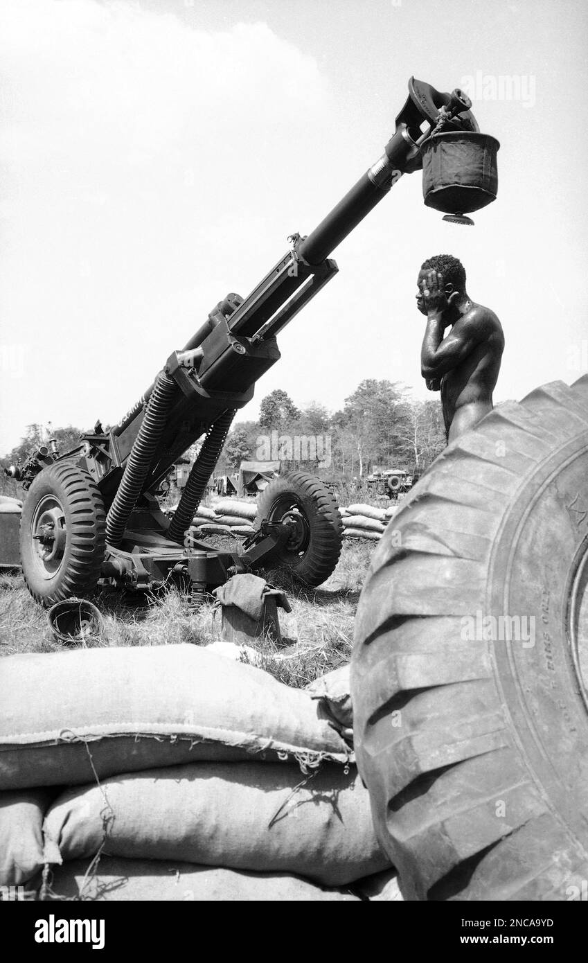 American GI uses muzzle of a 105-mm howitzer for an in-the-field shower ...