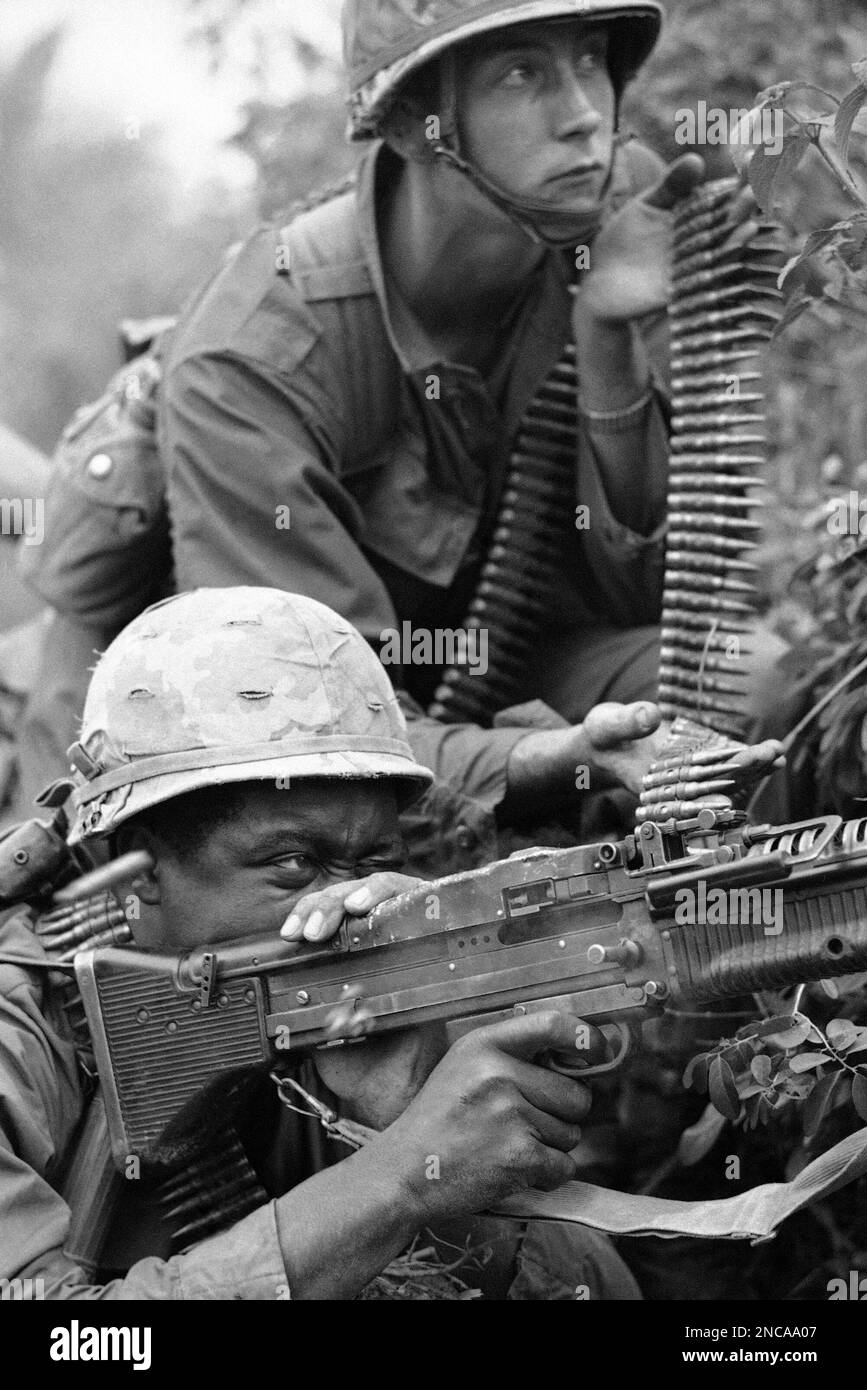 Machinegun team huddles behind bushes in a hedgerow and returns the ...