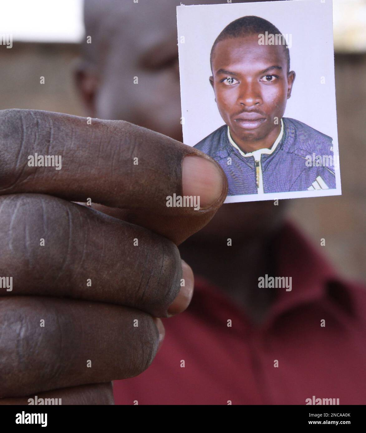 Raymond Okello the father of Oliver Okello , 20,displays a photo of his ...