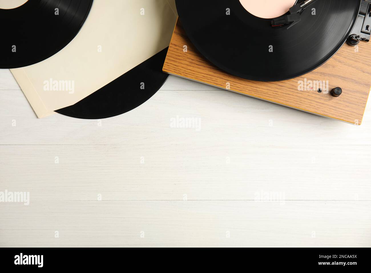 Vintage vinyl records and turntable on white wooden background, flat ...
