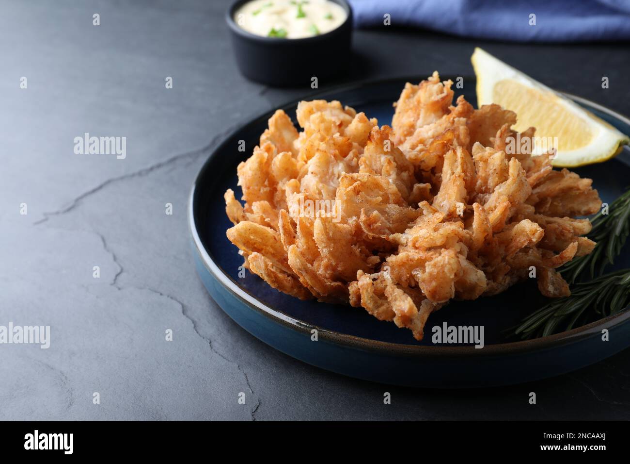 Delicious onion blossom served on black table, space for text Stock ...