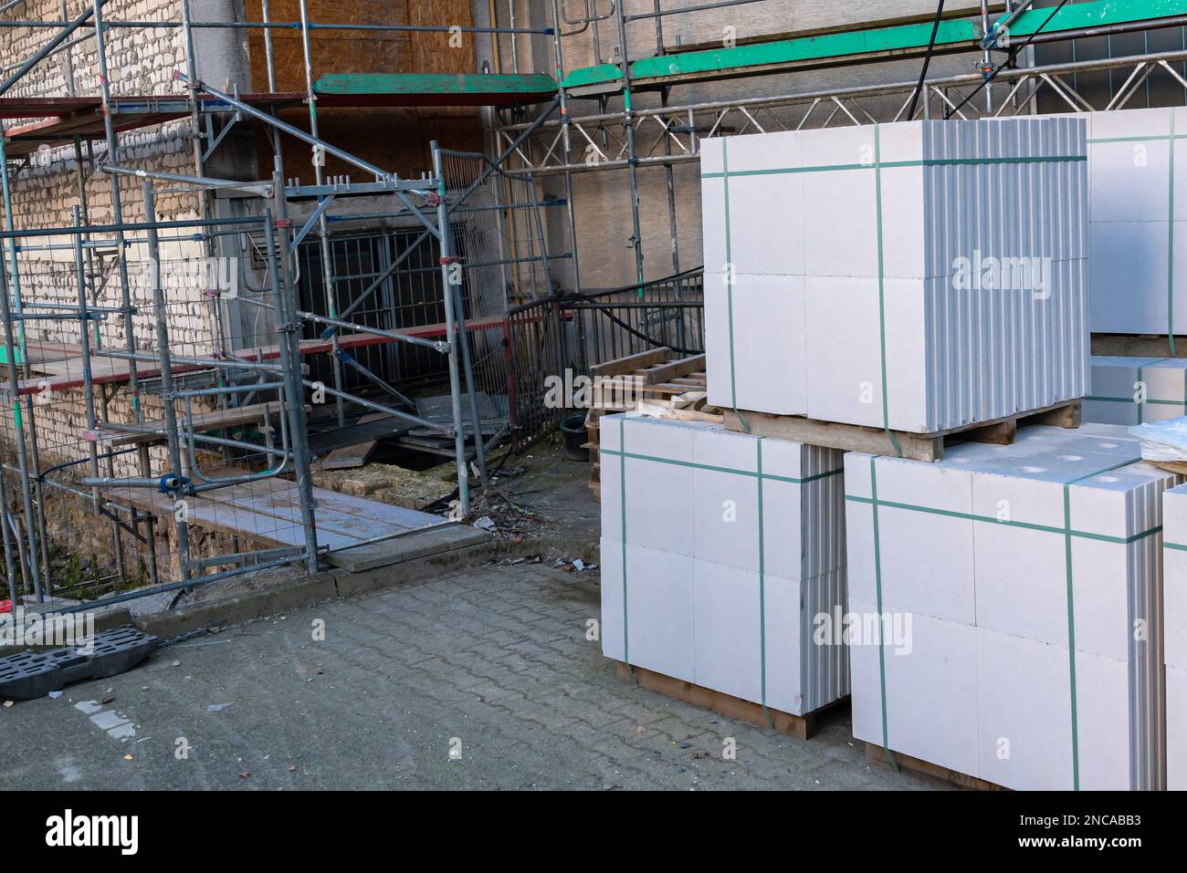 White building panels on wooden pallets at a construction site ...