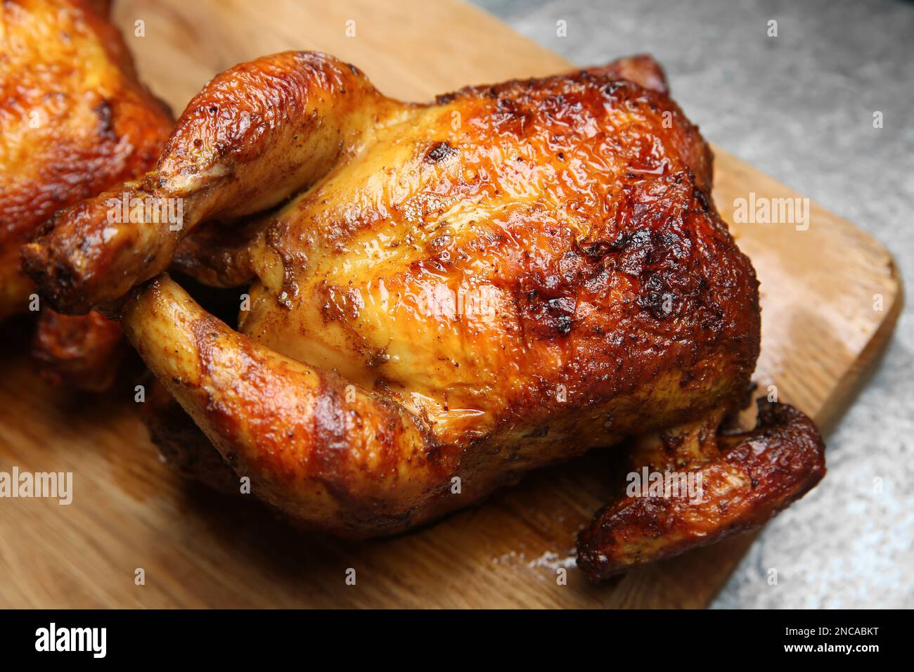 Delicious grilled whole chickens on grey table, closeup Stock Photo - Alamy