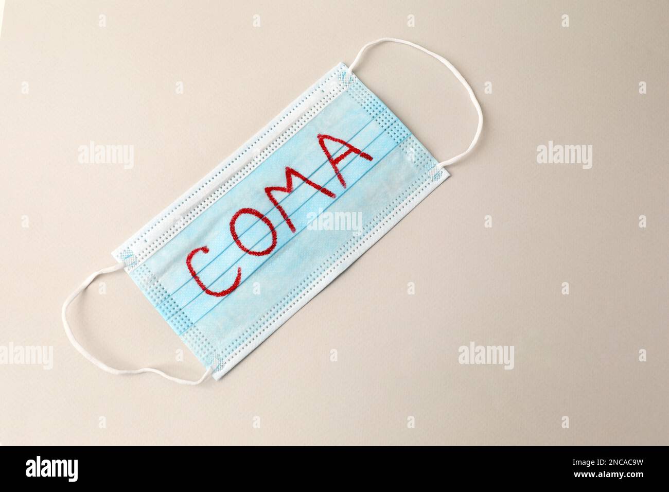 Medical mask with word Coma on beige background, top view Stock Photo ...