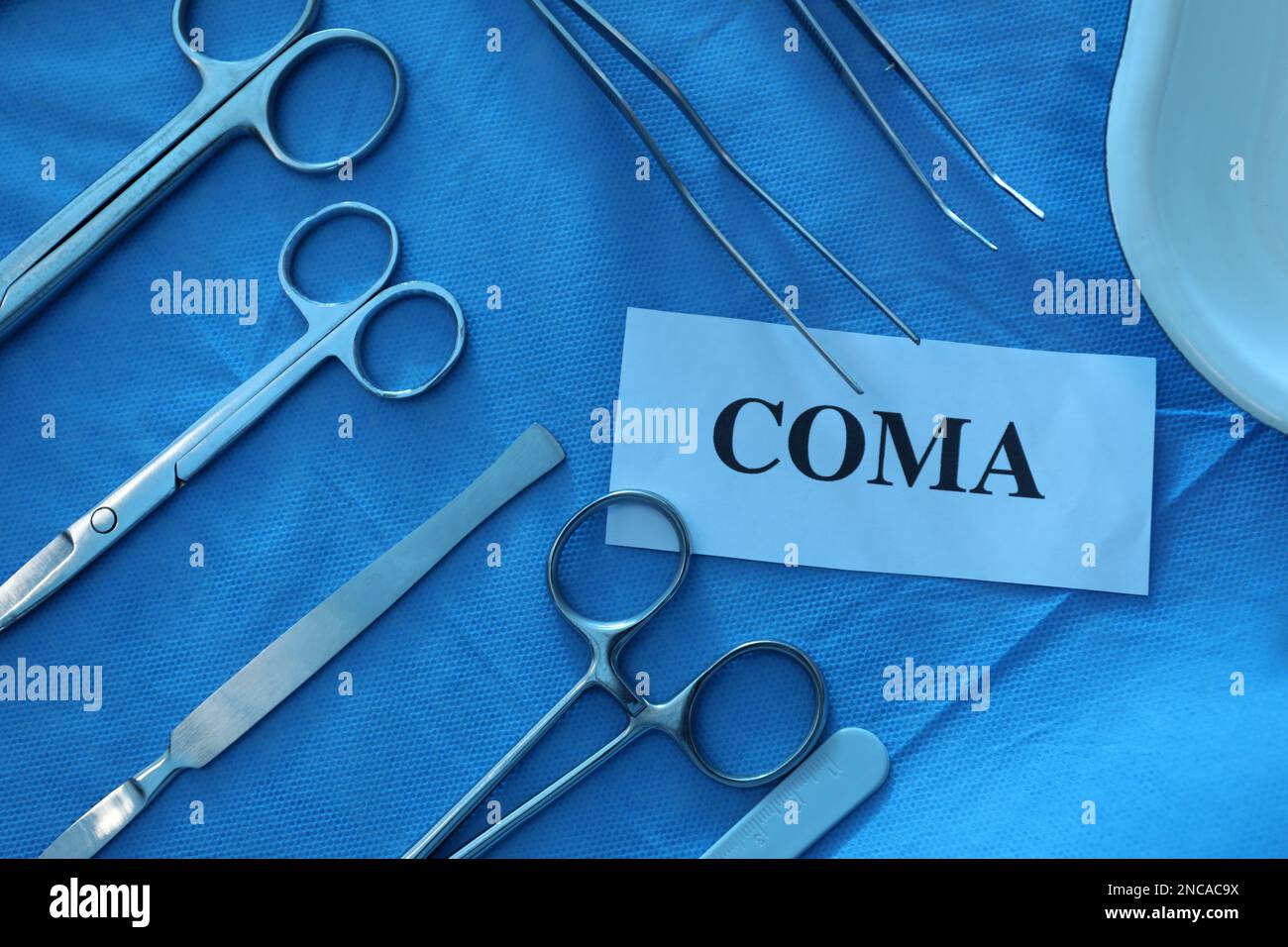 Card with word Coma and surgical instruments on table, flat lay Stock ...