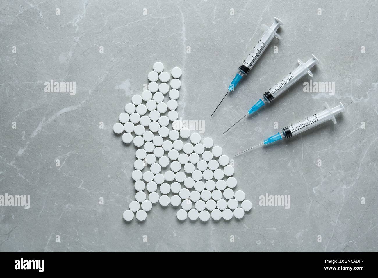 Rabbit figure of pills and syringes on light marble table, flat lay ...