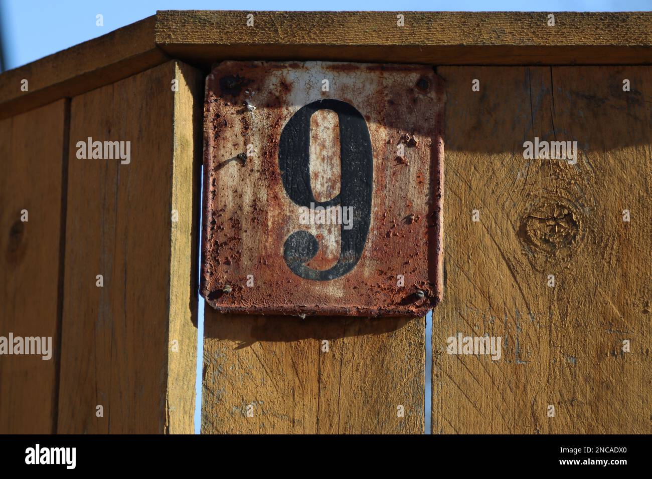 house number 9 yellow wooden fence with a metal address sign, old ...
