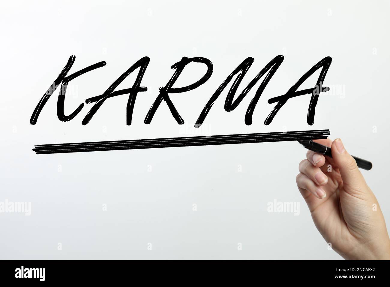 Woman writing word KARMA on glass against white background, closeup ...
