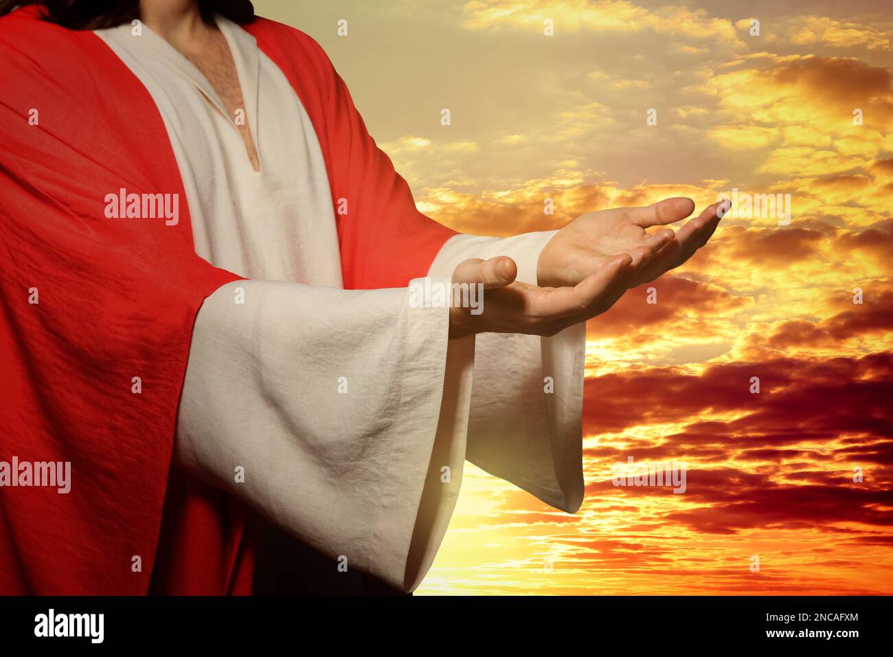 Jesus Christ reaching out his hands and praying at sunset Stock Photo ...