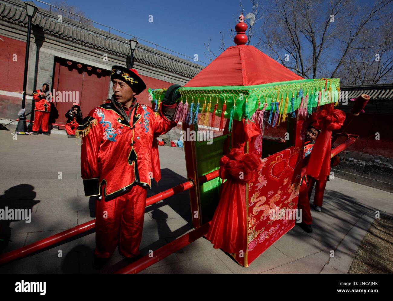 Men in traditional costumes wait for customers to offer the experience ...