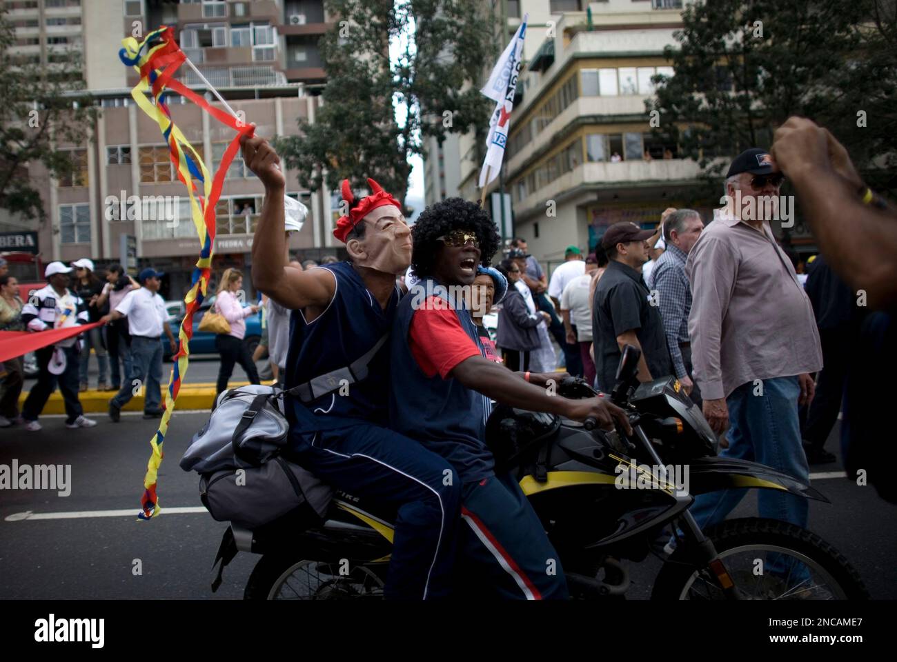 Men, one wearing a mask depicting Venezuela’s President Hugo Chavez ...