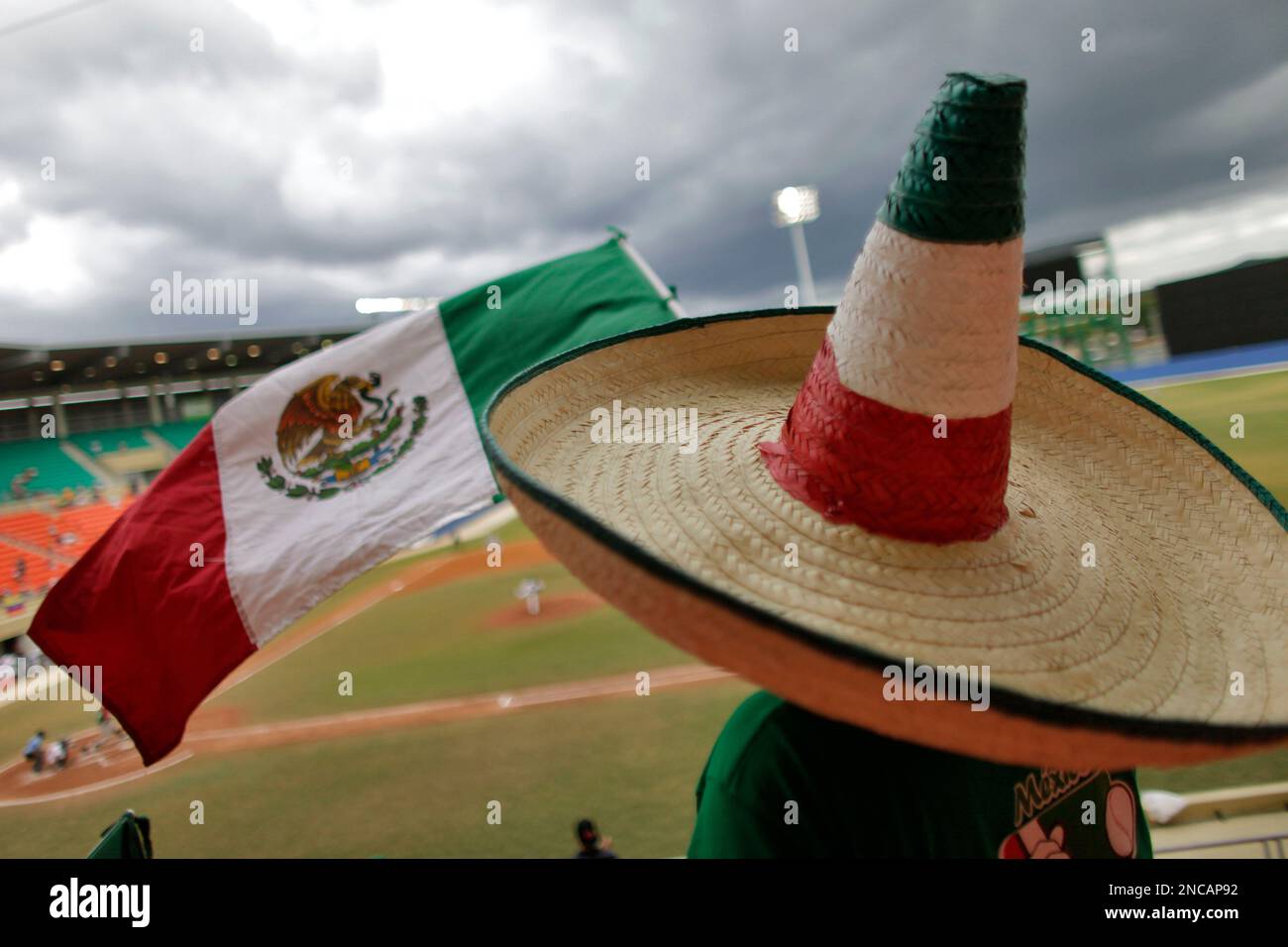 A fan wearing a traditional Mexican hat waves a Mexican flag as he ...