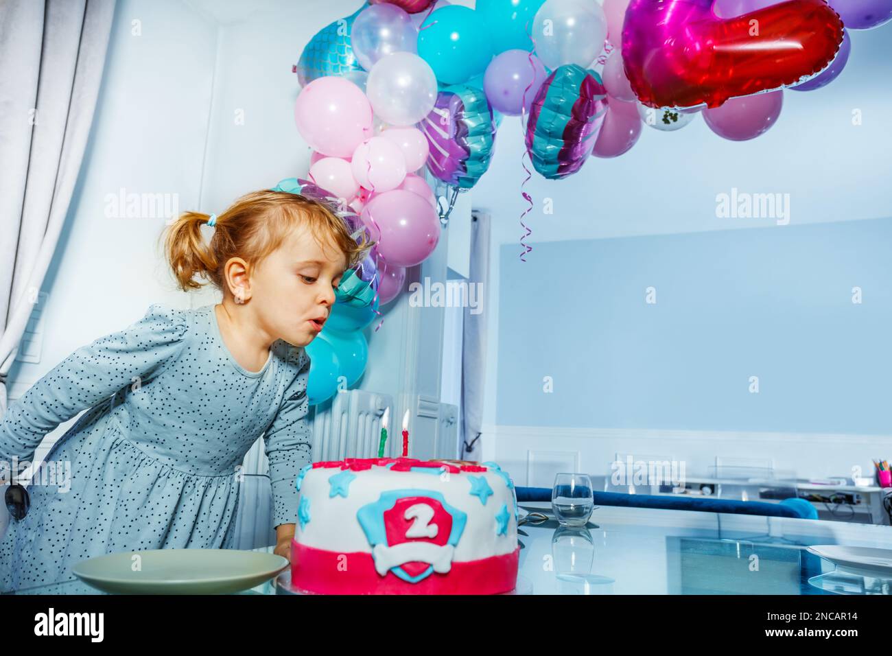 Happy little girl blow candles on the birthday cake party Stock Photo ...