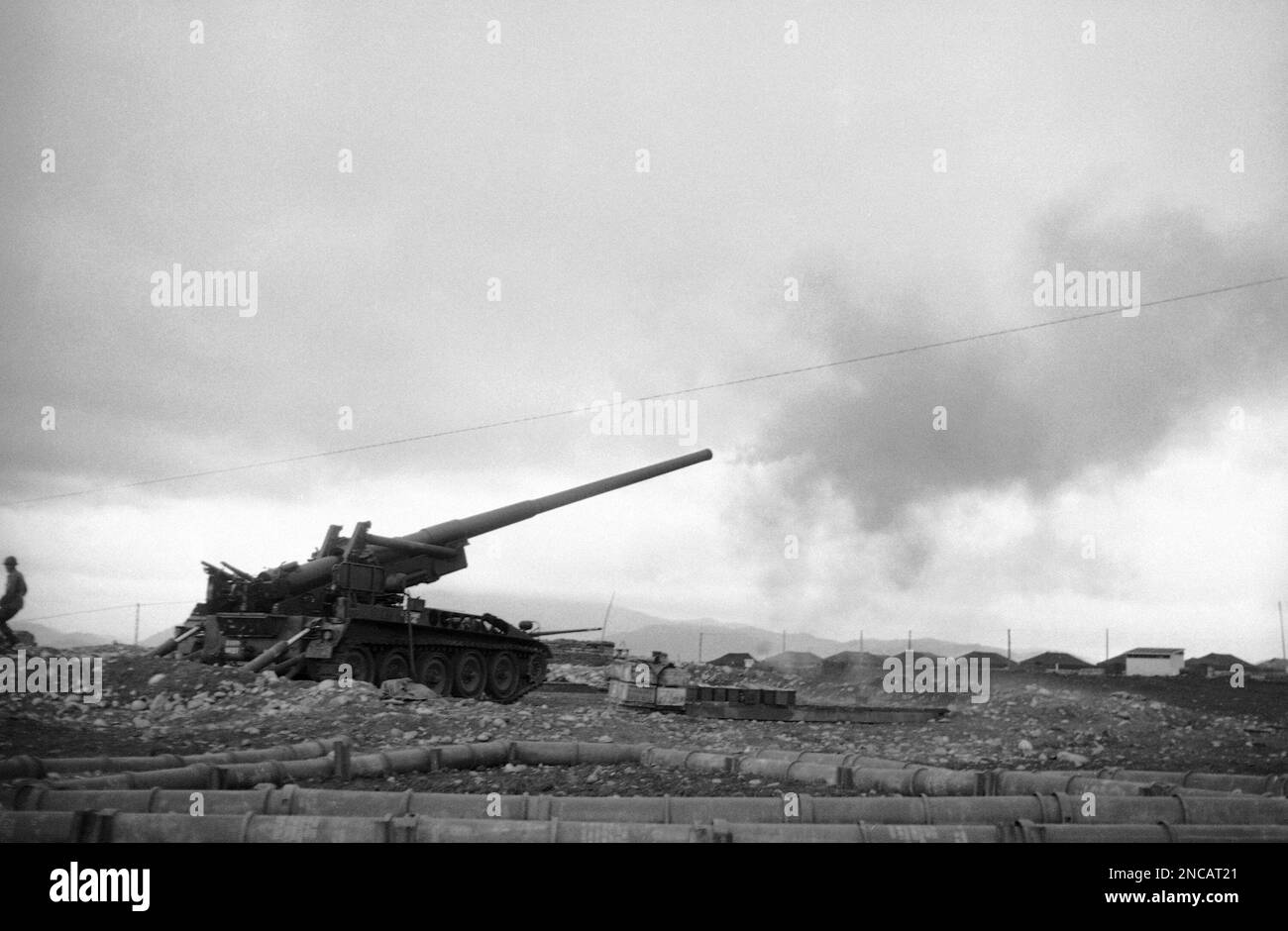U.S. artilleryman moves away from 175 mm gun as it belches smoke toward ...