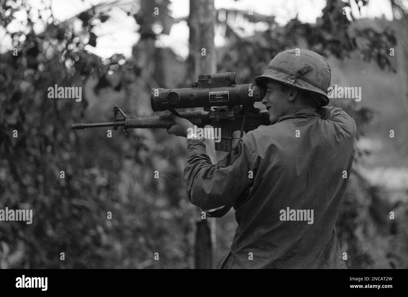 A cavalry soldier looks through a ‘starlight scope’ that is attached to ...