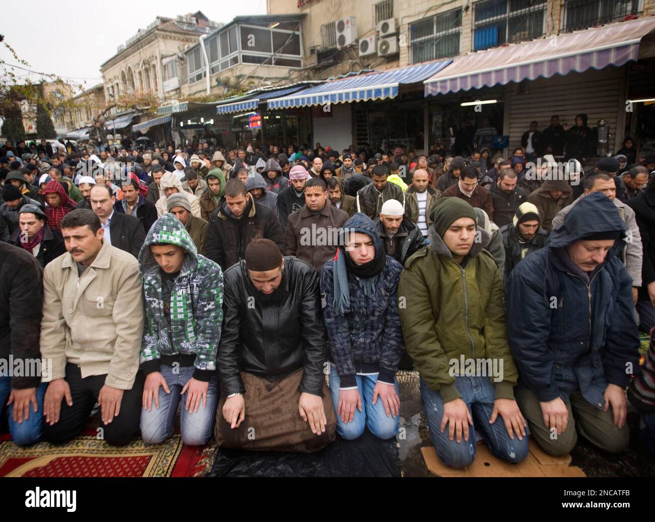Palestinian men pray during Muslim Friday noon prayers in a street in ...