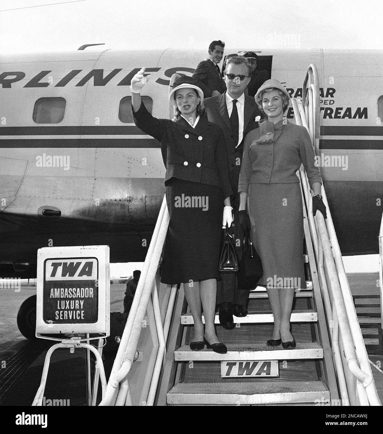 Film actress Ingrid Bergman, left, waves greeting from ramp of plane ...