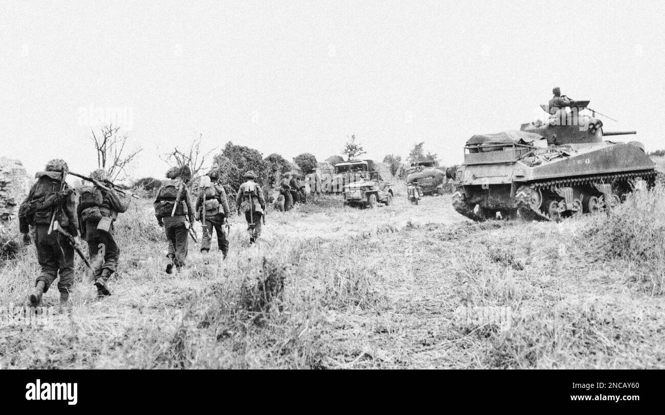 British tanks and infantrymen push on through the village of Gruchy, in ...